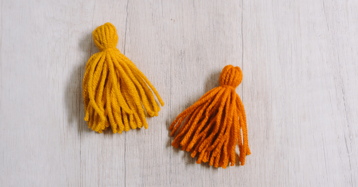 How to Make Yarn Tassels | DIY Tassel Tutorial with Yarn - Laura Radniecki