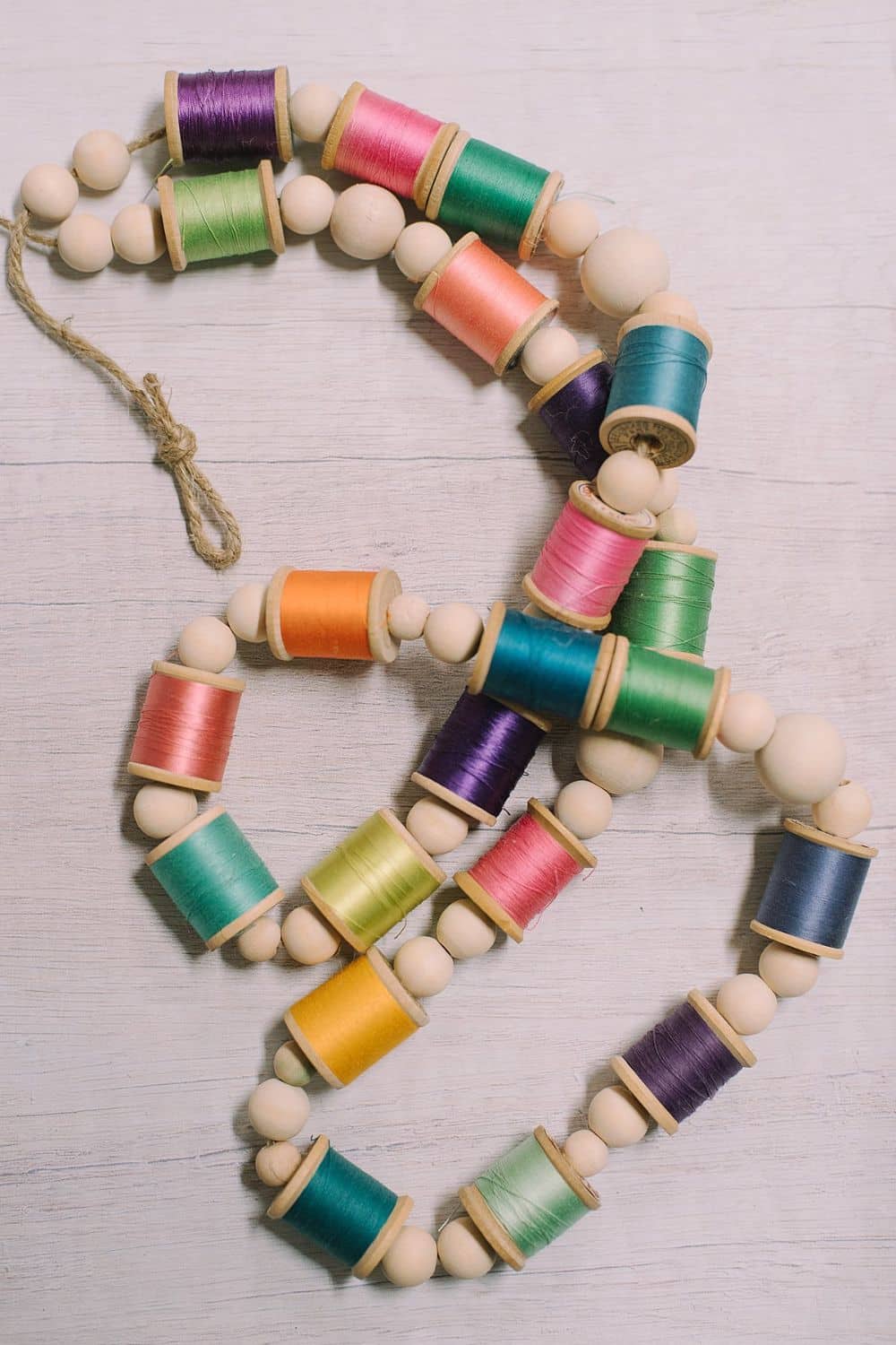DIY Colorful Garland with Spools of Thread and Wooden Beads - Laura ...